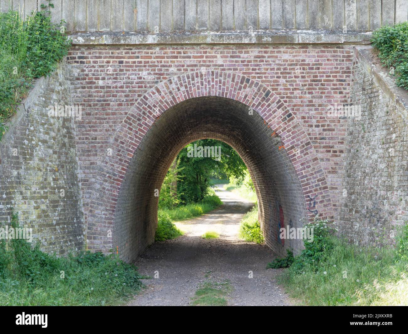 A medieval brick tunnel over a footpath under the bright sunlight Stock ...