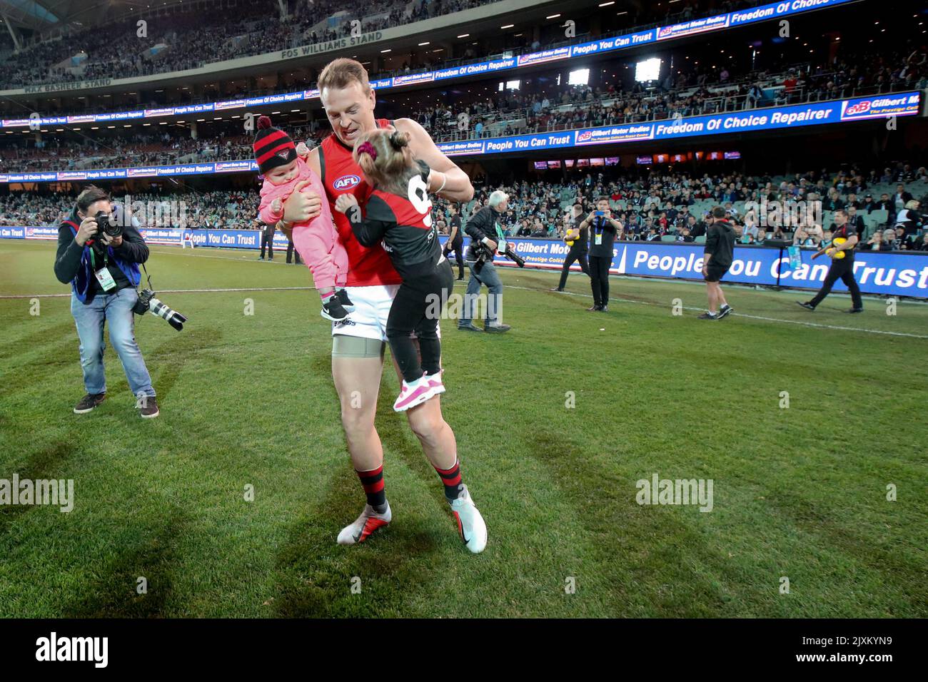 Brendon Goddard of the Bombers runs out with his kids at the start of ...