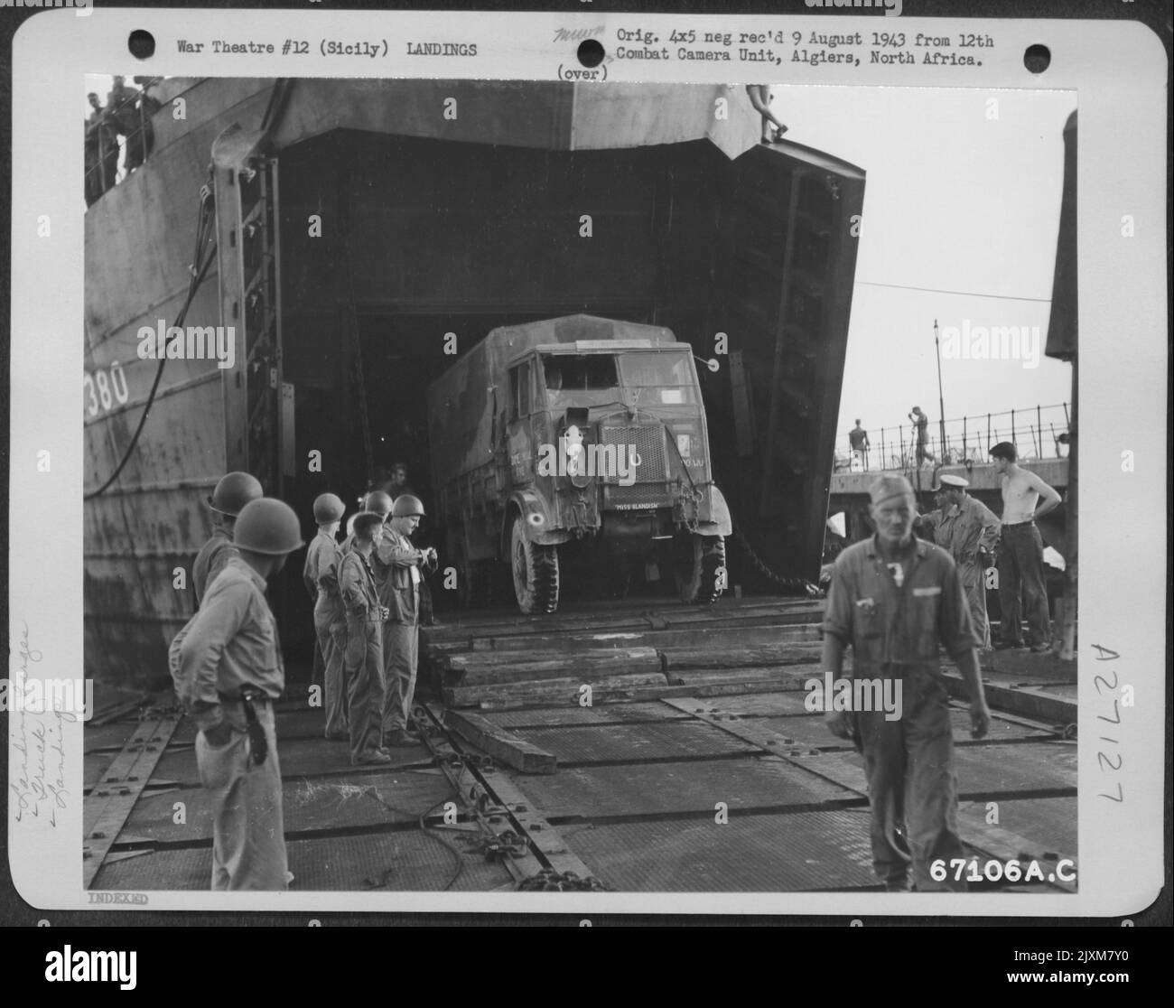 A truck, loaded with equipment, rolls down the ramp of the LST (Landing ...