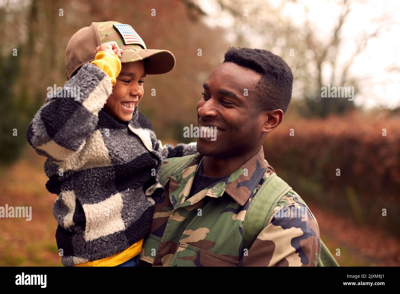 American Soldier In Uniform Returning Home To Family On Leave With Son Wearing Army Cap Stock ...