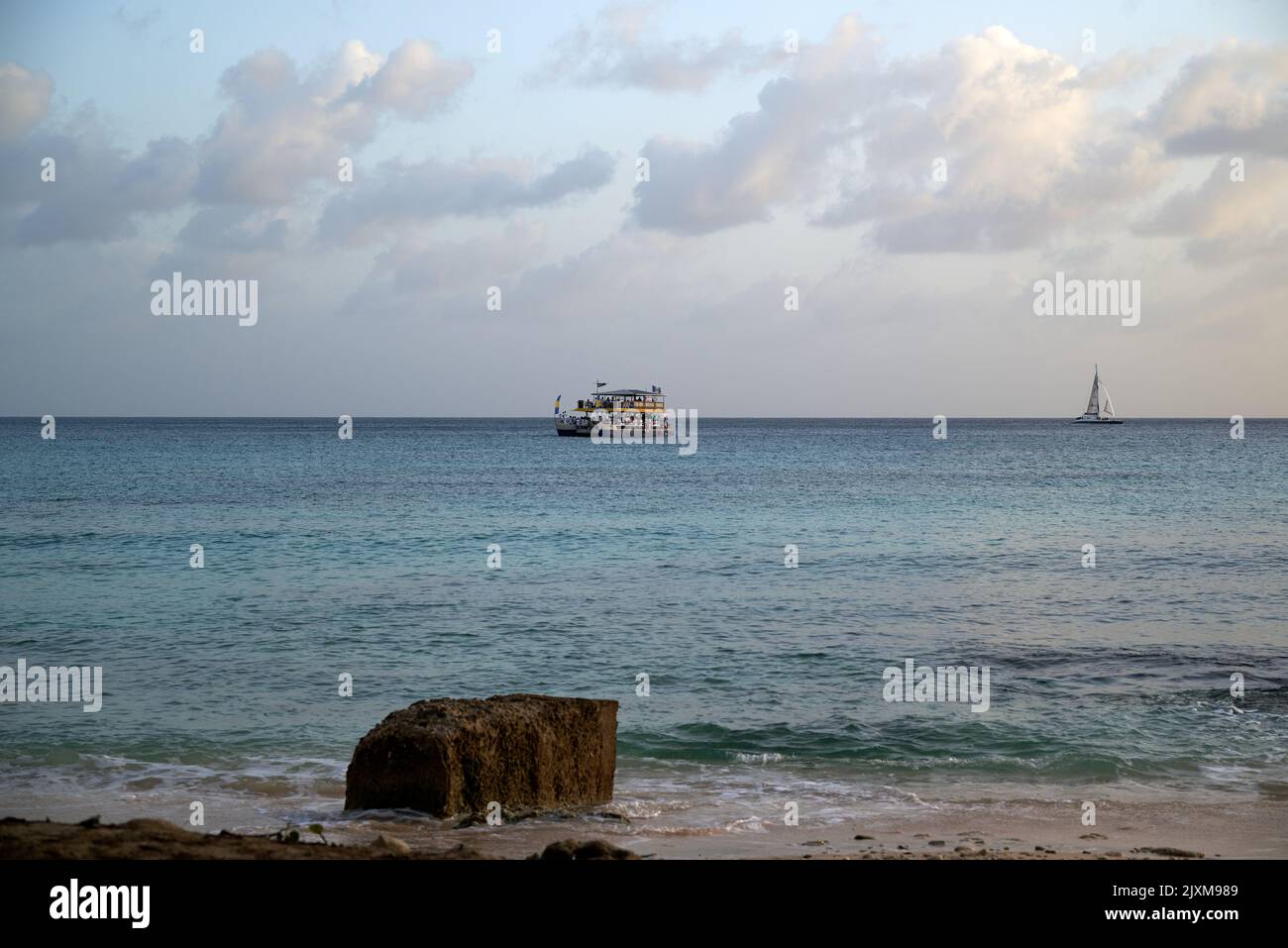 A lonely stone in front of the beautiful gradient ocean with boat and ...