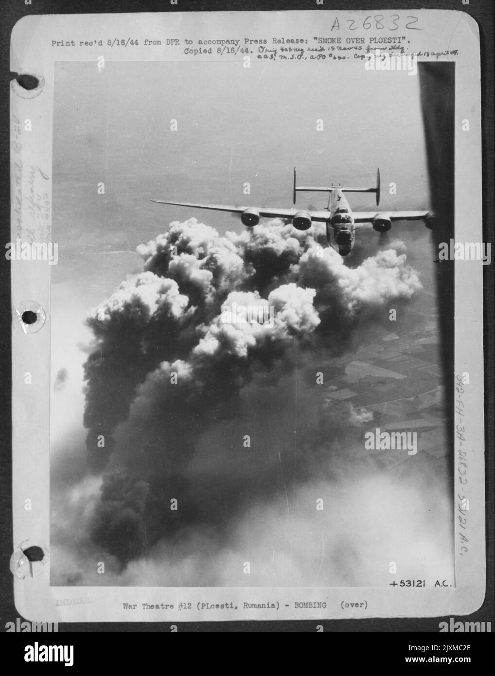 Rising above this towering column of smoke is a Consolidated B-24 ...