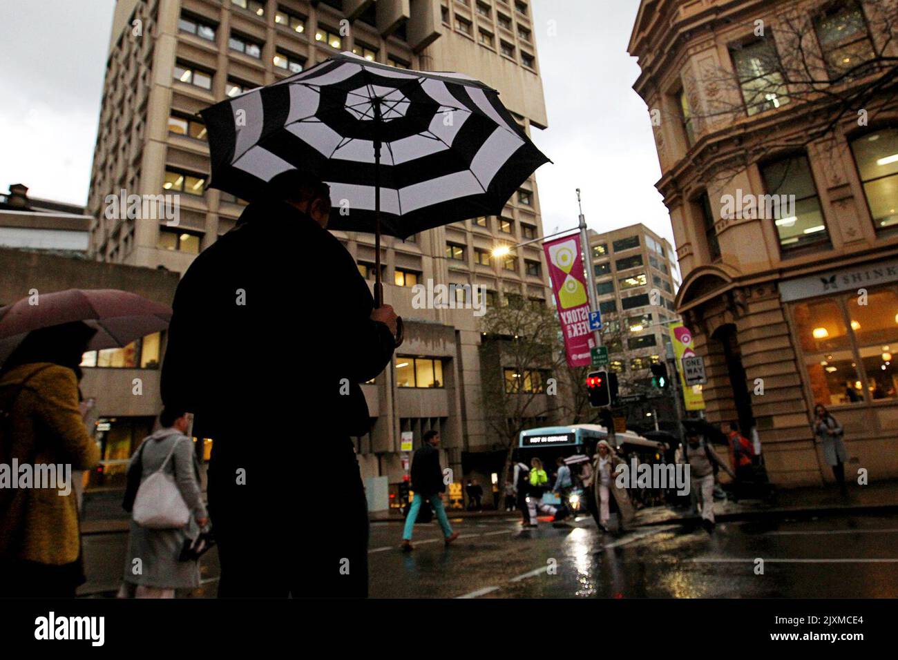 Pedestrians are seen as heavy rain falls in Sydney, Friday, September 7 ...