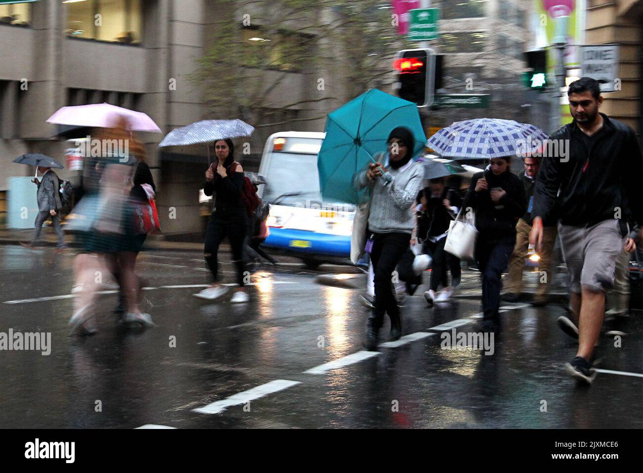 Pedestrians are seen as heavy rain falls in Sydney, Friday, September 7 ...