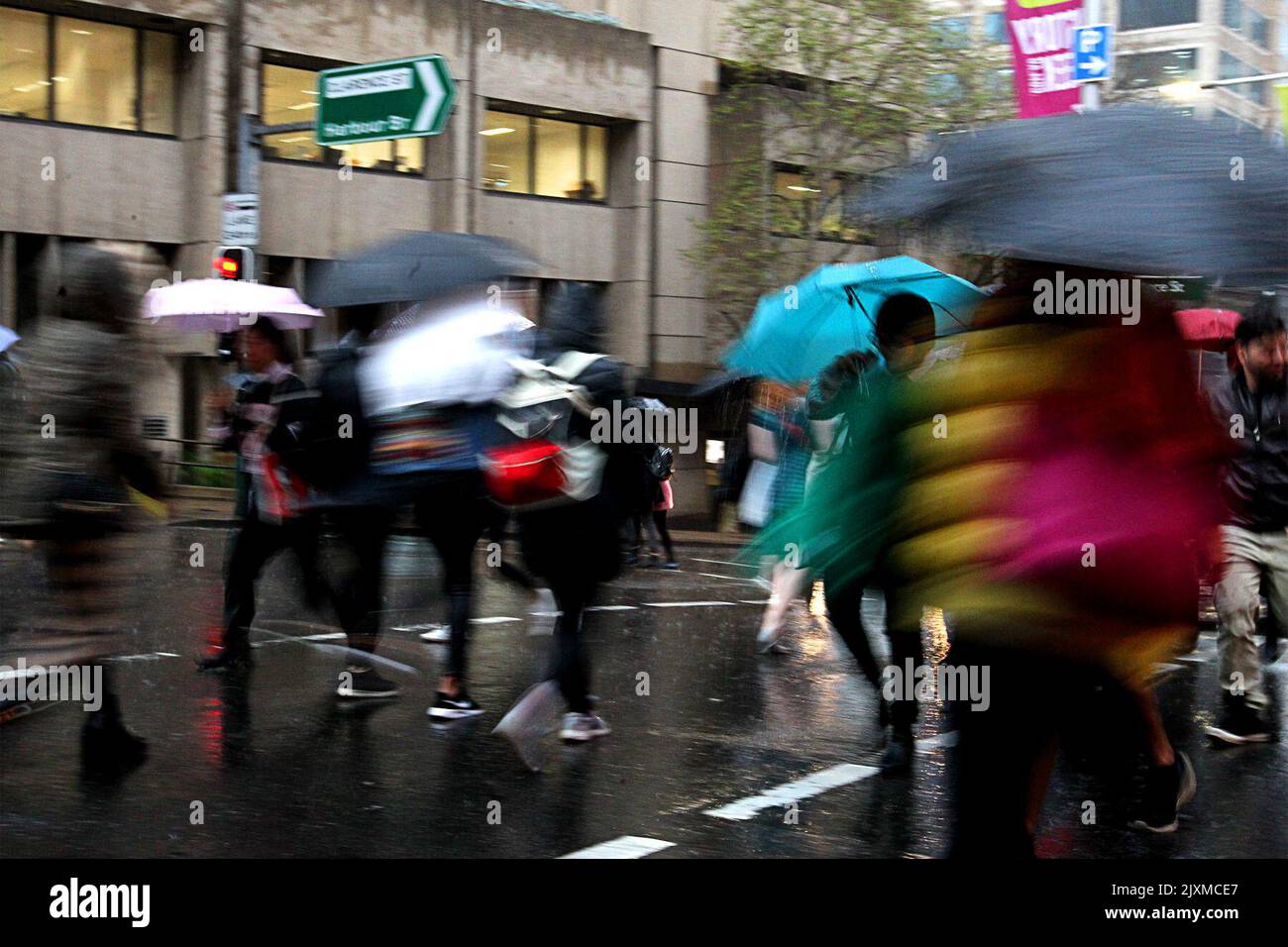 Pedestrians are seen as heavy rain falls in Sydney, Friday, September 7 ...