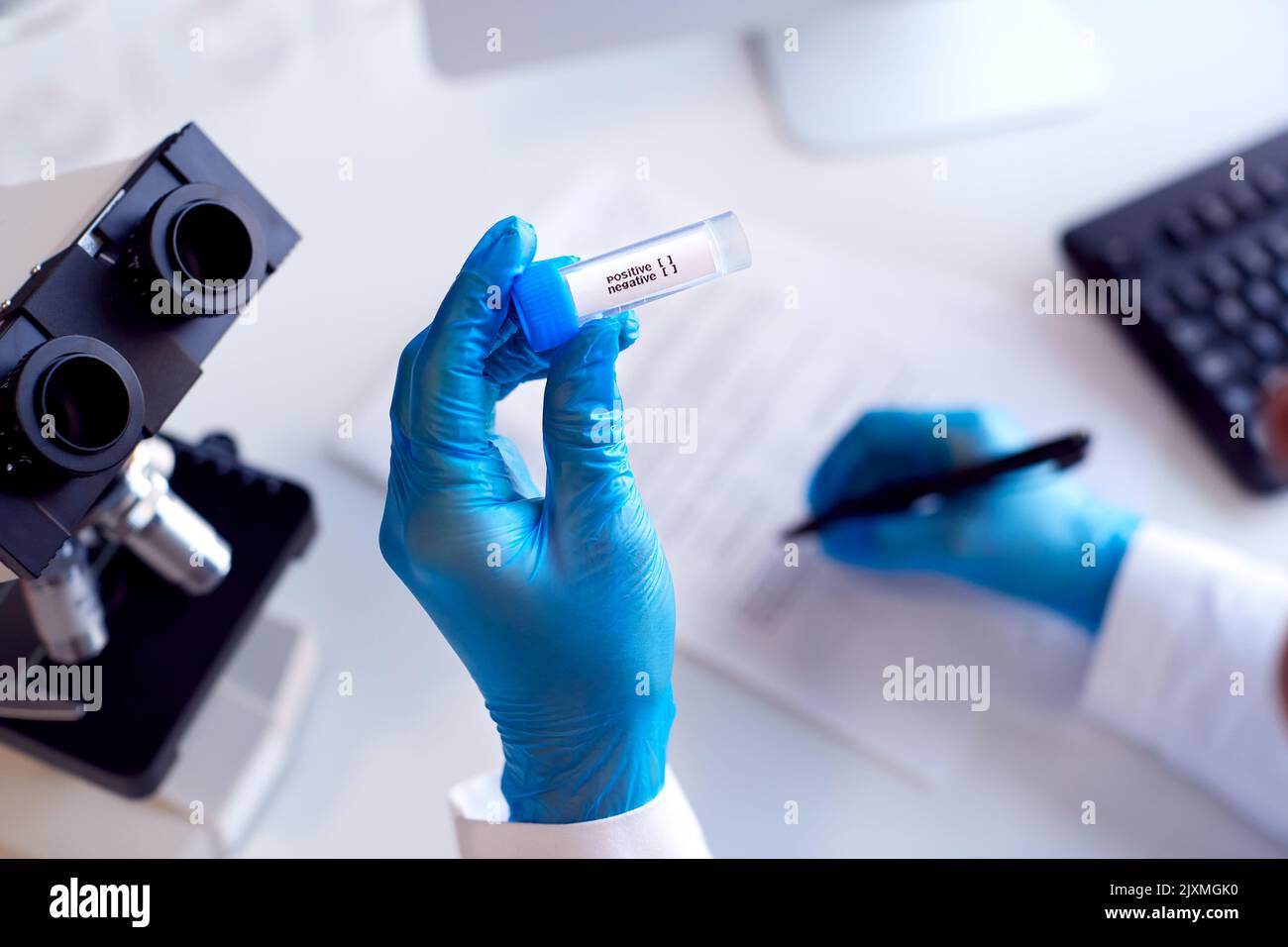 Close Up Of Lab Worker Doing Test Using Microscope Holding Test Tube ...