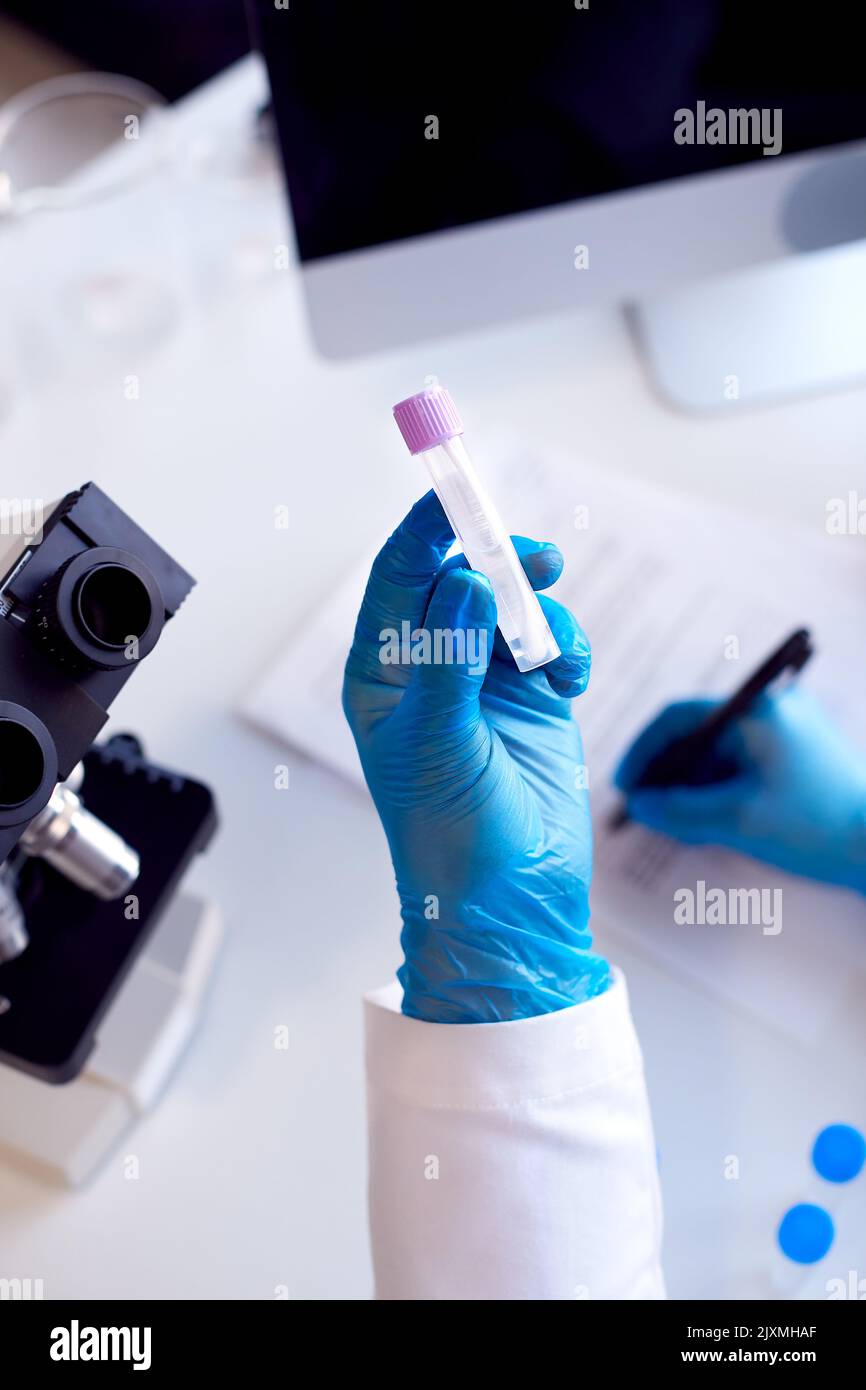 Close Up Of Lab Worker Conducting Research Using Microscope Holding ...