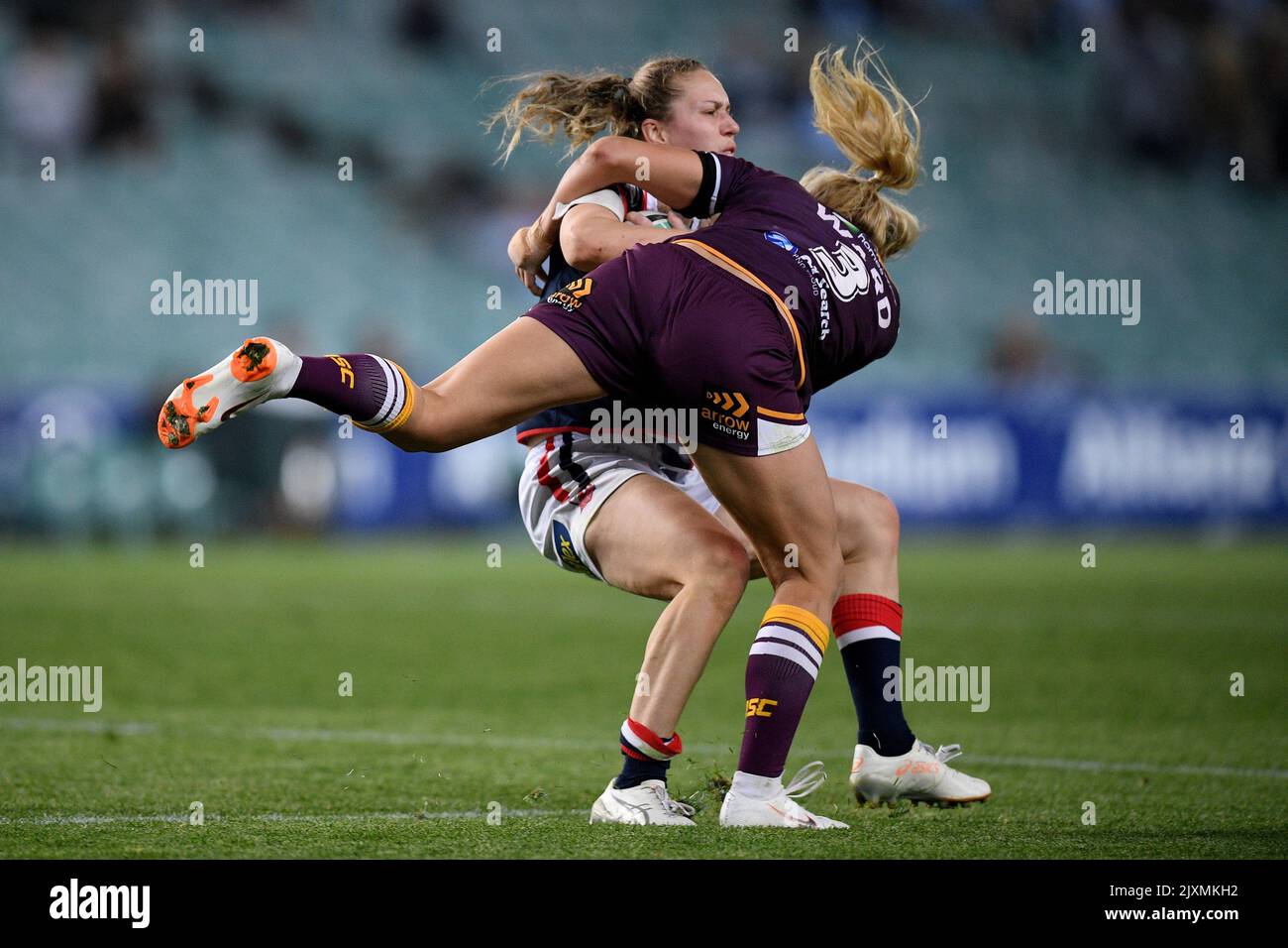 Karina Brown of the Roosters is tackled by Meg Ward of the Broncos ...