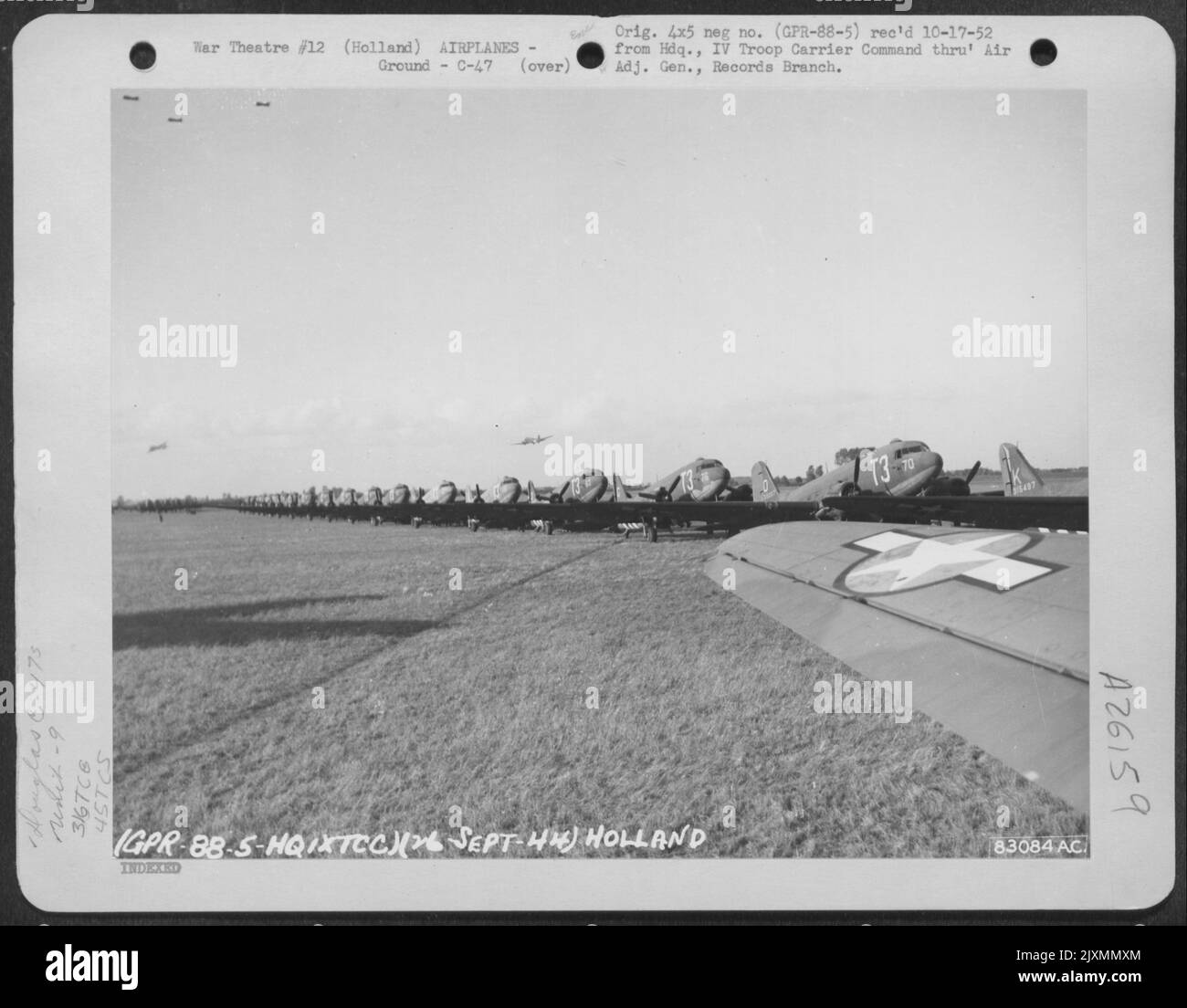 Douglas C-47s of the 9th Troop Carrier Command lined up on a field ...
