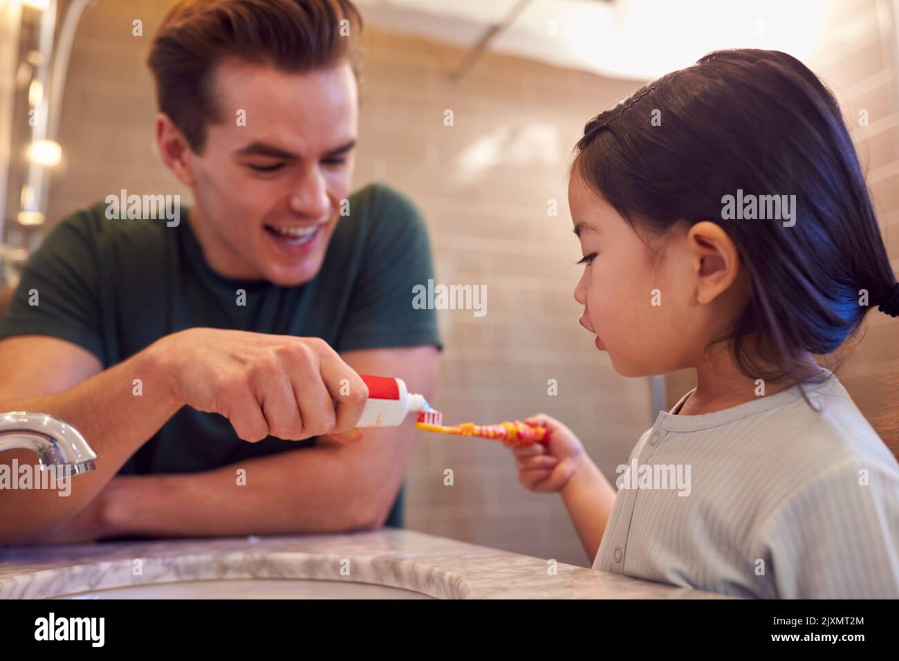 Family With Dad Helping Daughter With Toothpaste As She Brushes Teeth ...