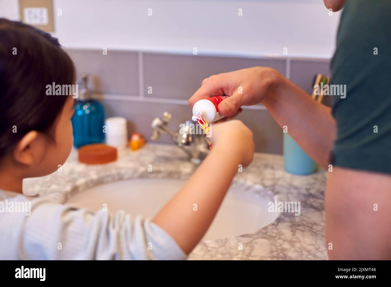Family With Dad Helping Daughter With Toothpaste As She Brushes Teeth ...
