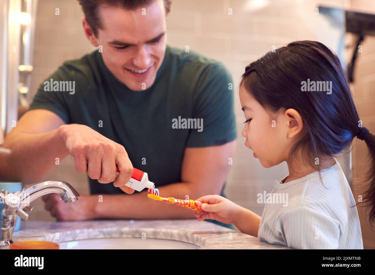 Family With Dad Helping Daughter With Toothpaste As She Brushes Teeth ...