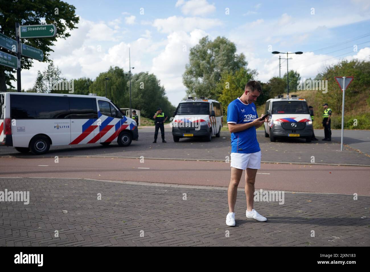A Rangers fan stands near police vans outside the ground before the ...
