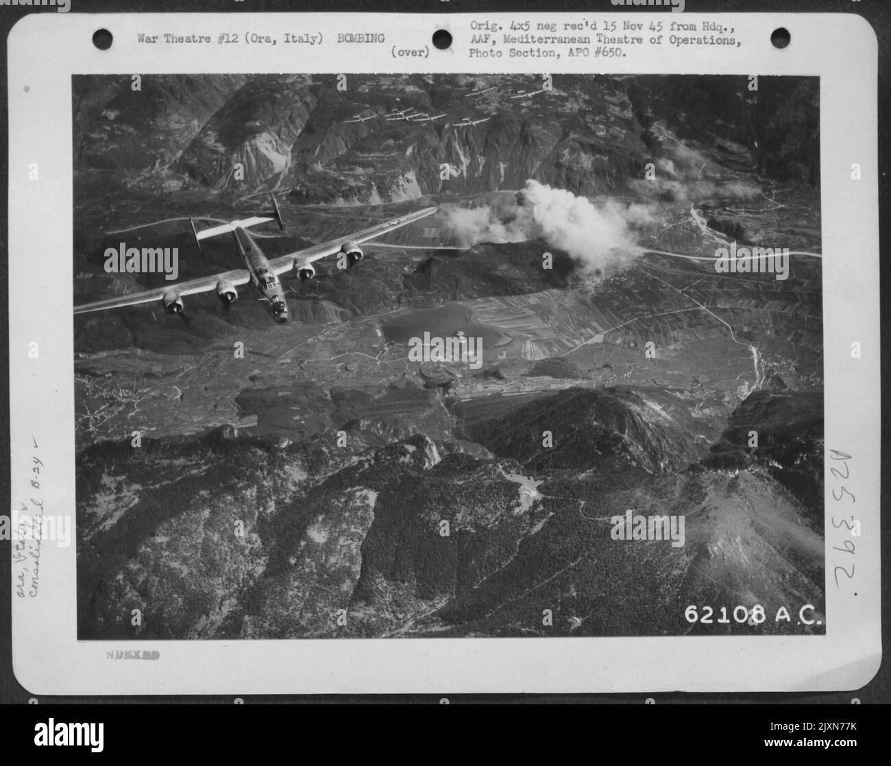 A Consolidated B-24 Liberator leaves the target at Ora, Italy, smoking ...