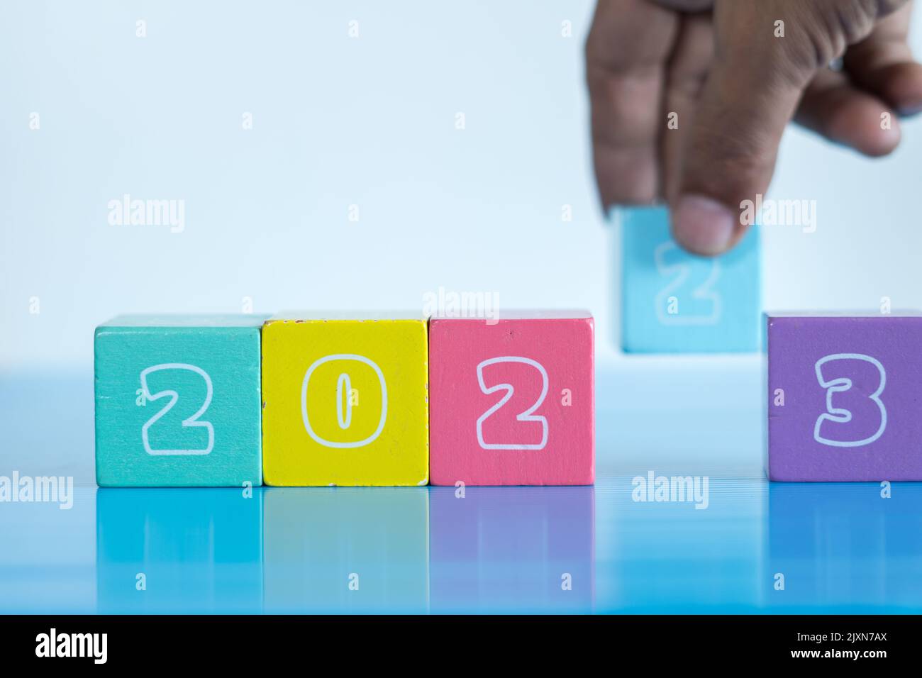 A hand picking a cube with the number 2 of the 2022 year and leaving ...