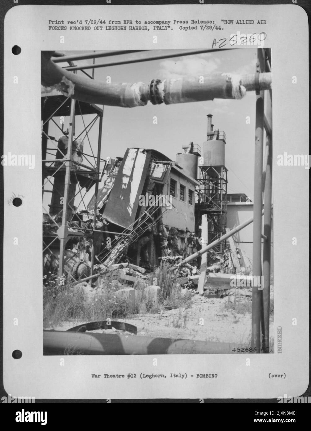 Oil drums lie under the debris from shattered buildings after bombs of ...
