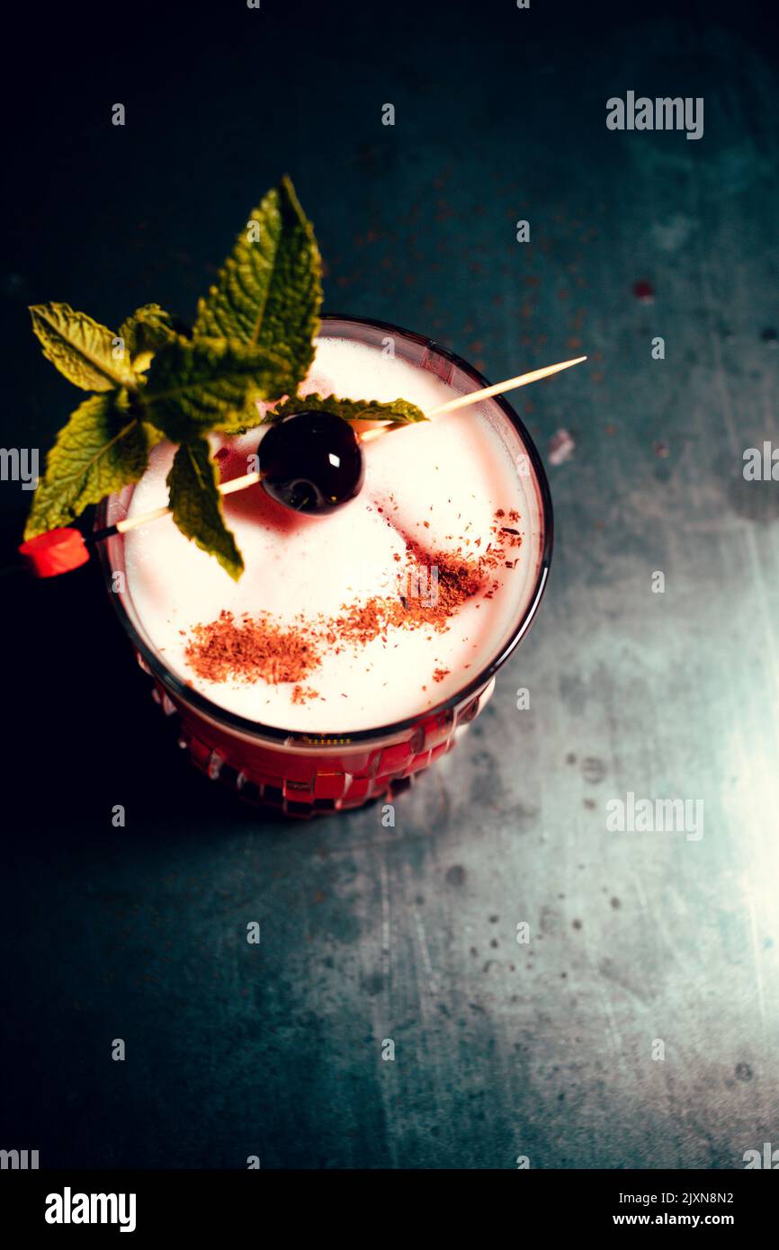 A vertical shot of a red cocktail with a white foam on top Stock Photo ...