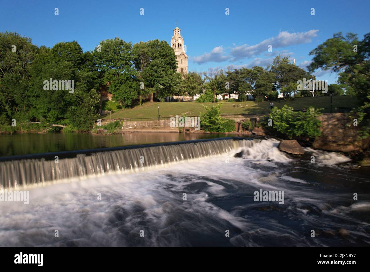 A top view of dam over a river surrounded by lush green trees under ...