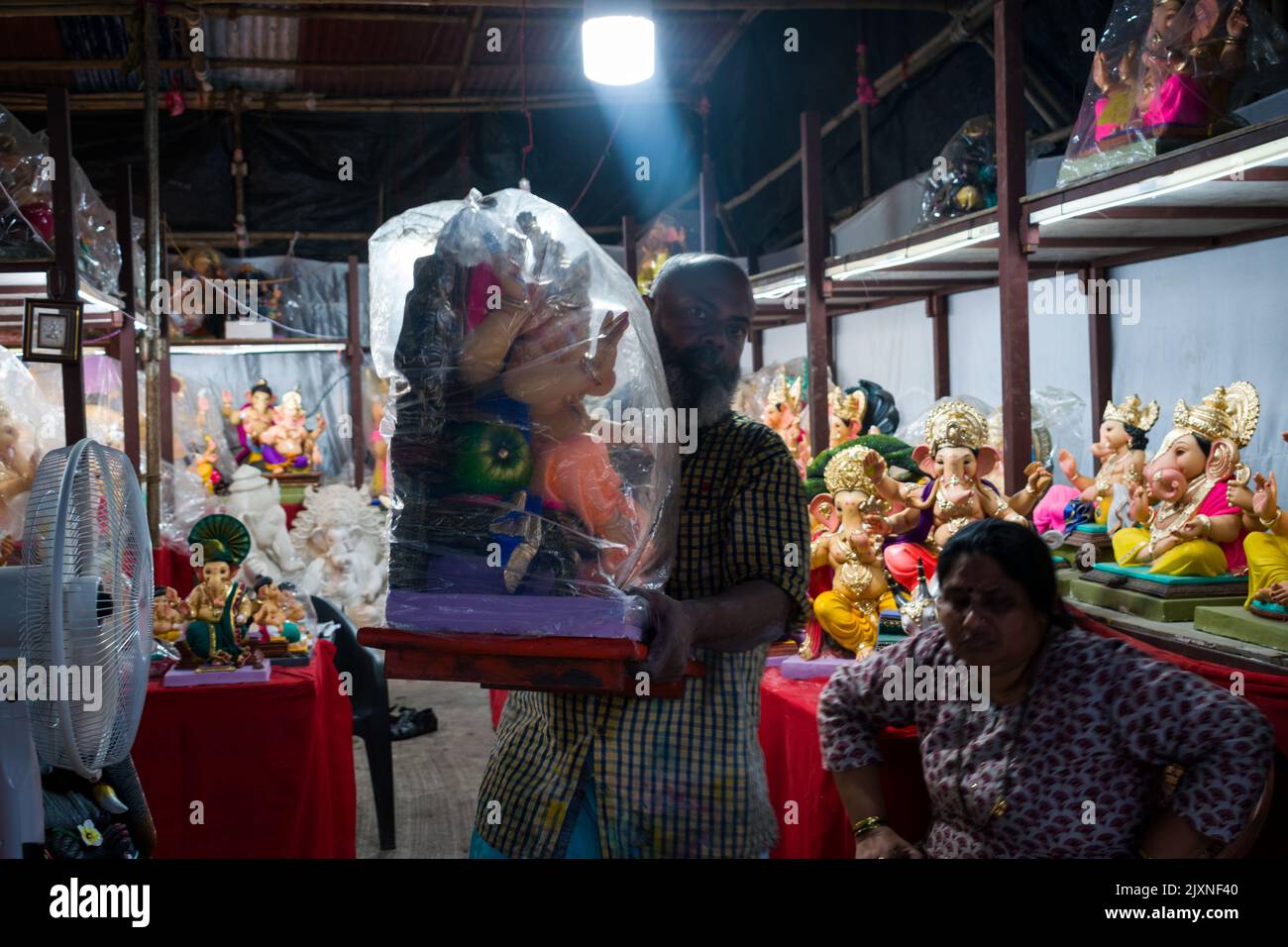 A man carrying a Ganpati idol at a workshop of Lord Ganesha idols in ...