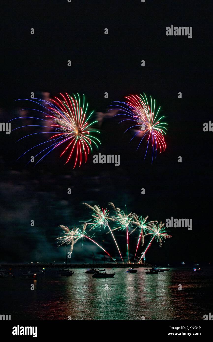 Beautiful colorful fireworks in the dark night sky during a celebration ...