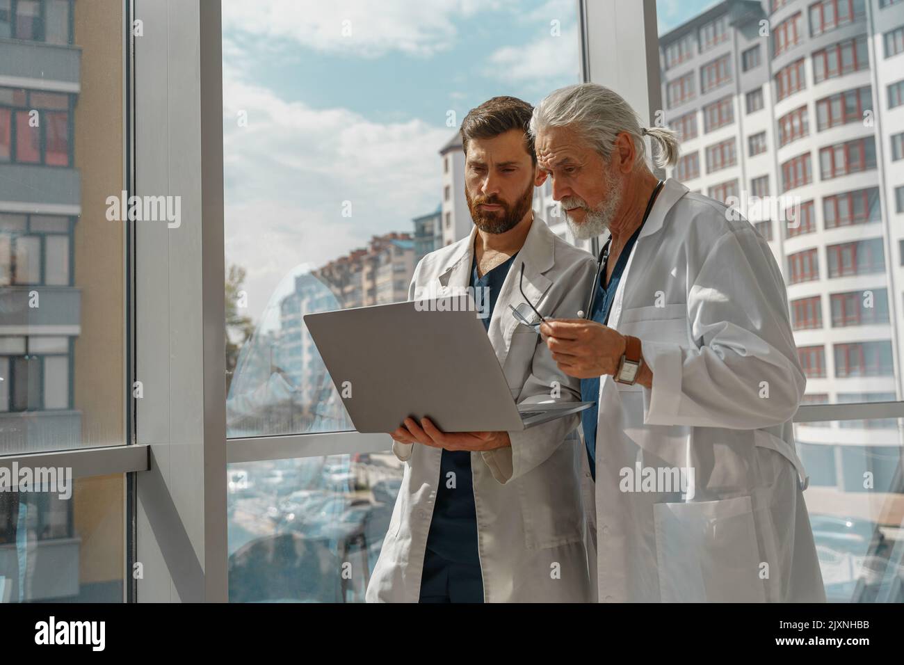 Two doctor colleagues discussing patient diagnosis stand in medicine ...