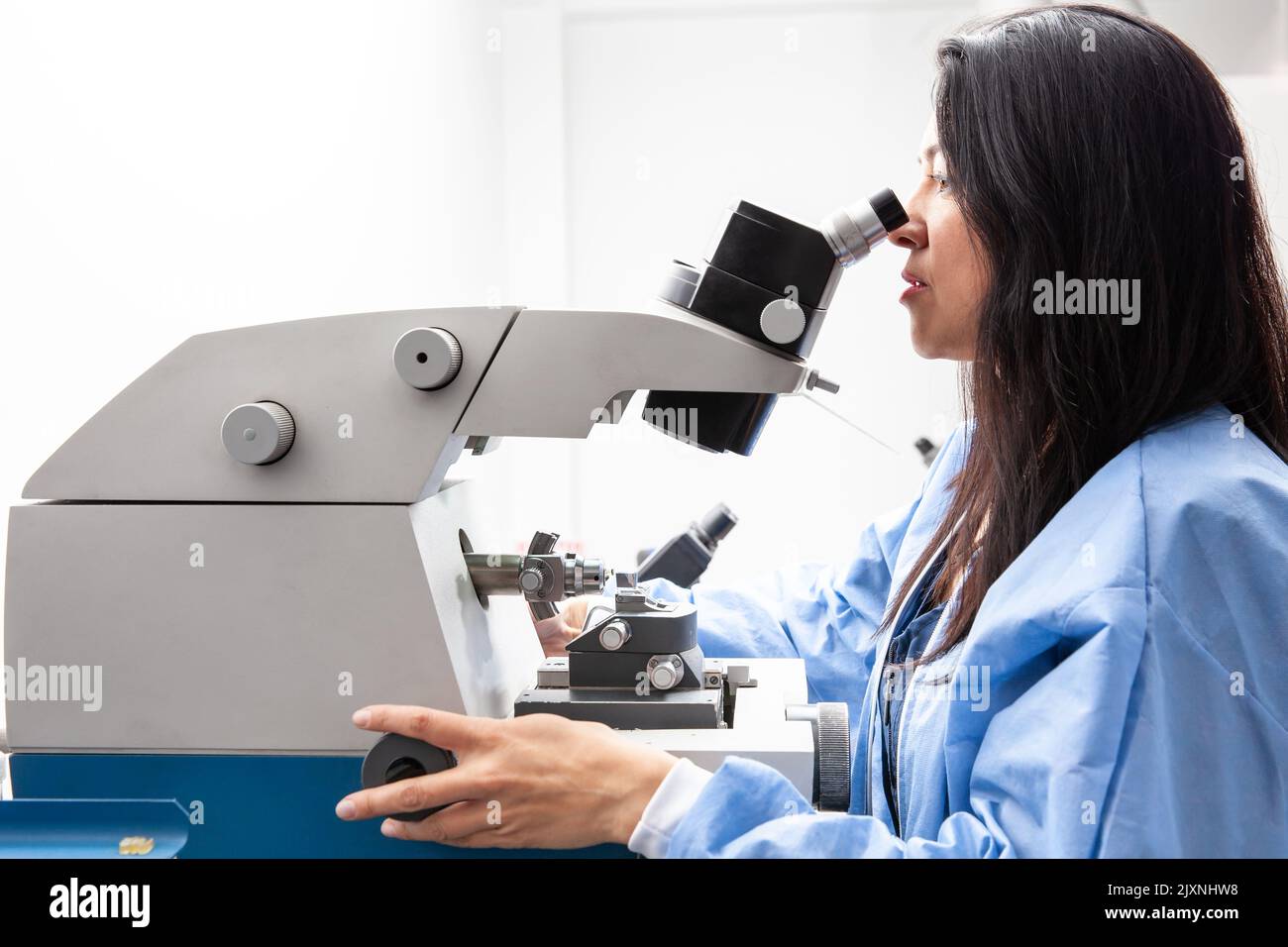 Young female scientist using an ultramicrotome to make sections for the ...