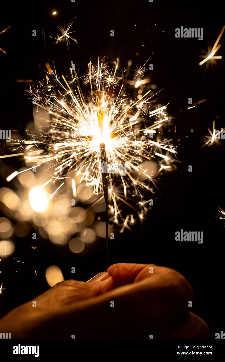 A lit sparkler burning, with a black background Stock Photo - Alamy
