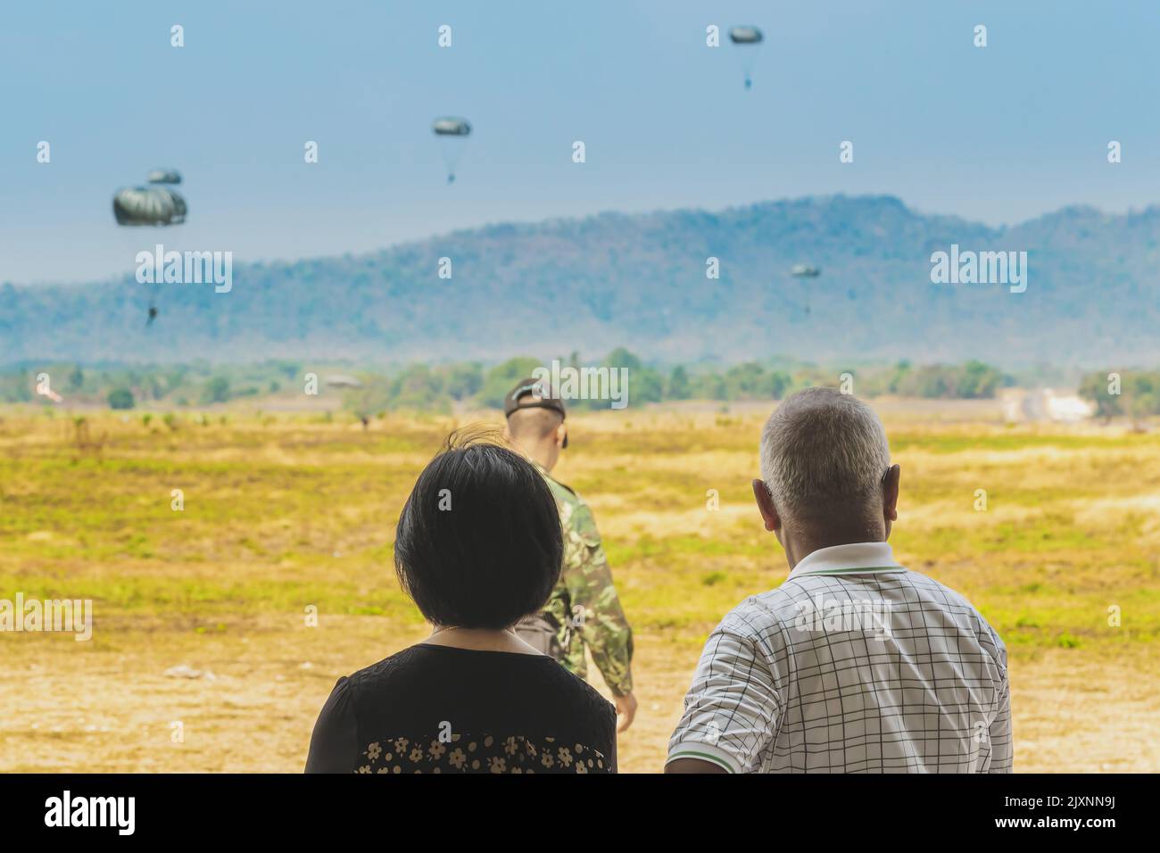 Back view of Asian parents look with worry and concern during parachute ...