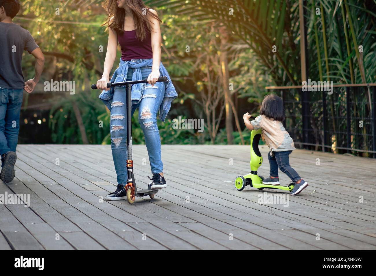 Asian woman enjoy playing and riding modern extreme stunt kick scooter ...