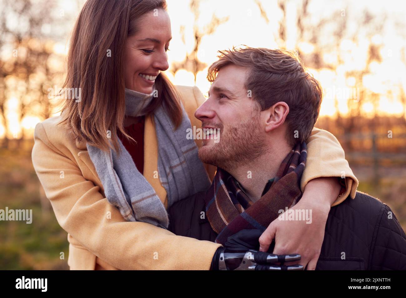 Portrait Of Romantic Couple With Woman With Prosthetic Hand Hugging in ...