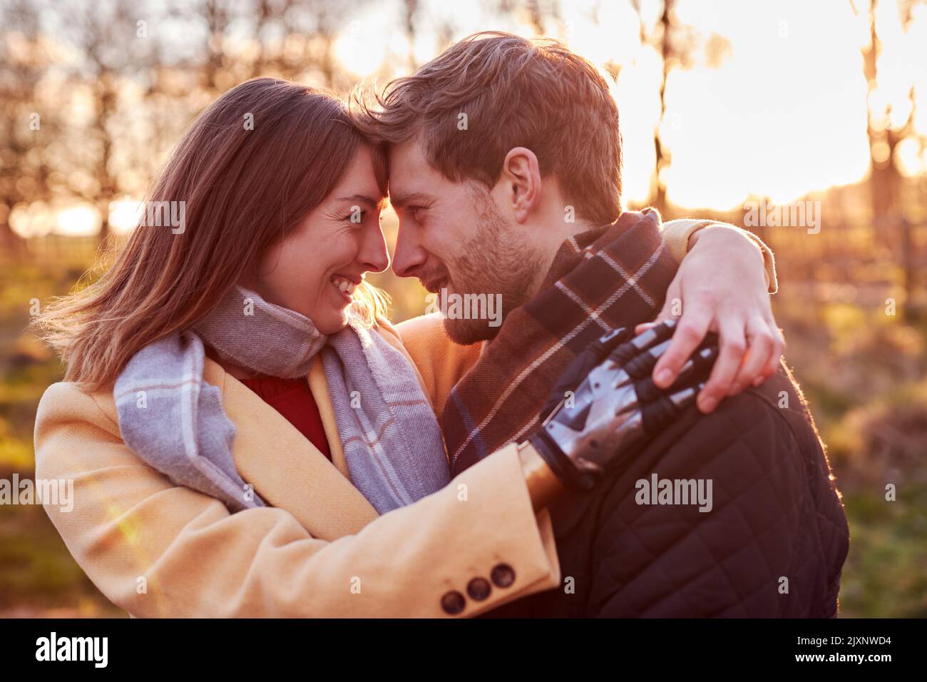 Portrait Of Romantic Couple With Woman With Prosthetic Hand Hugging in ...