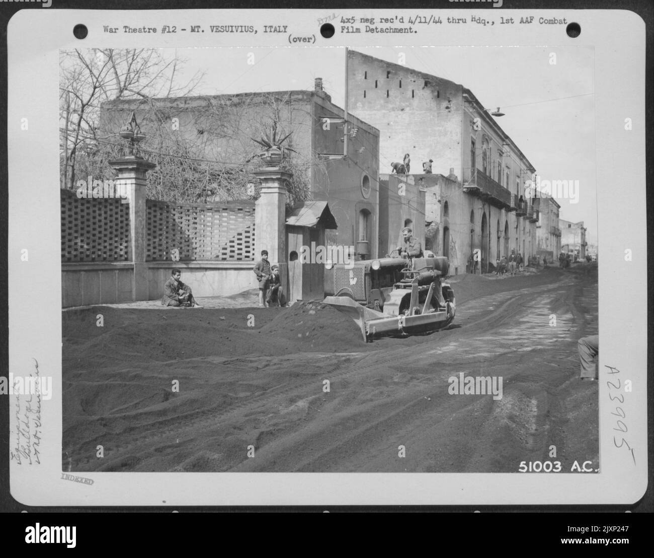 Bull-dozers push the lava cinders from the streets of Cercola, Italy ...