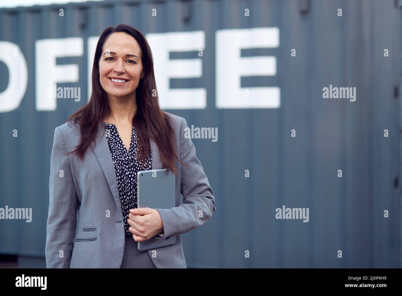 Portrait Of Female Freight Haulage Team Manager Standing By Shipping ...