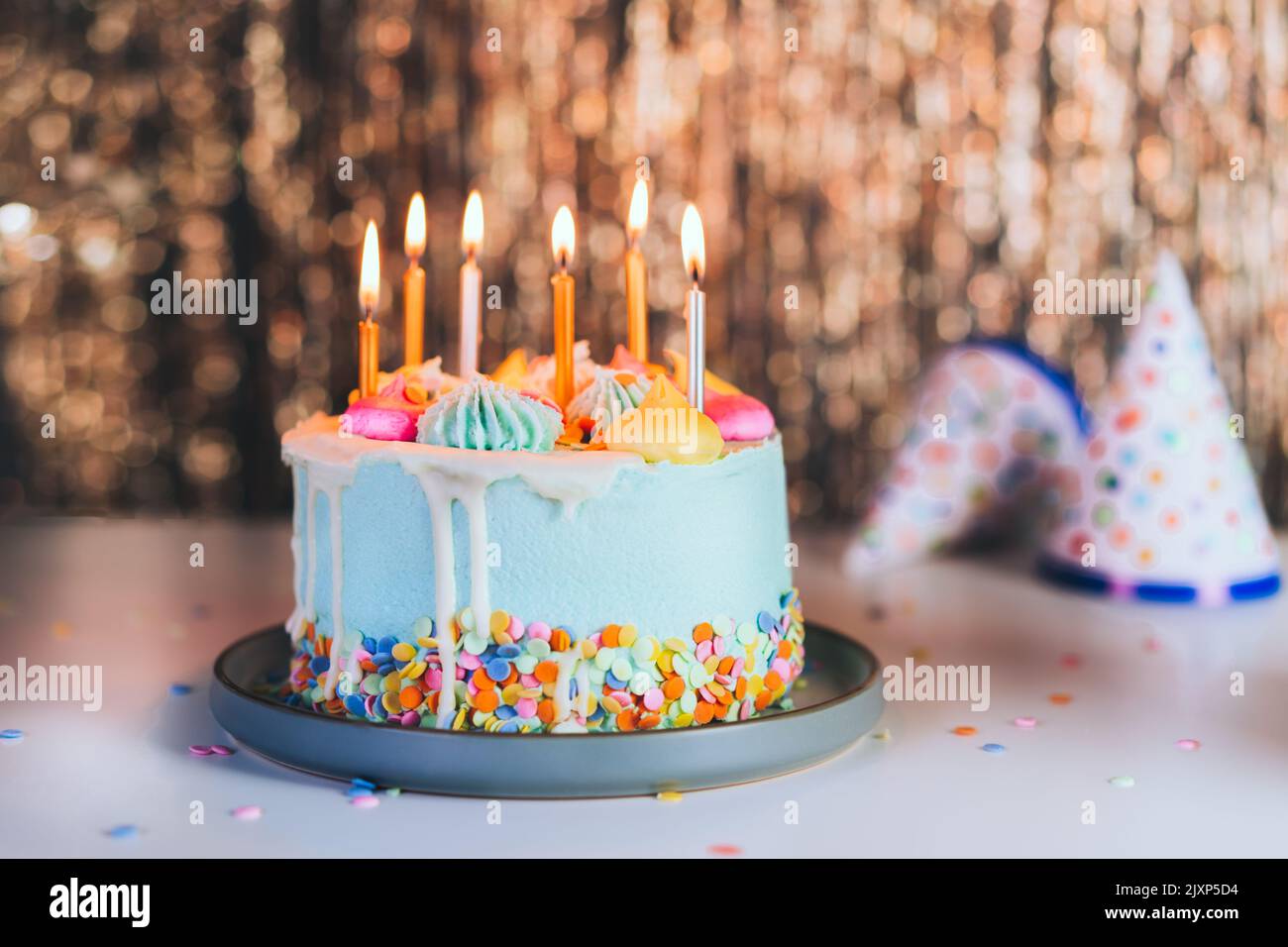 Colorful birthday cake with sprinkles and burning candles and festive ...