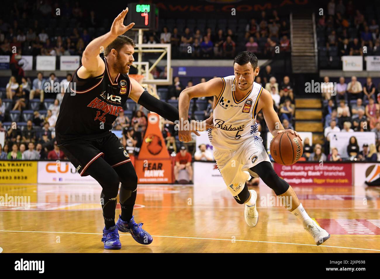 Brian Conklin of the Hawks applies pressure to Jason Cade of the ...