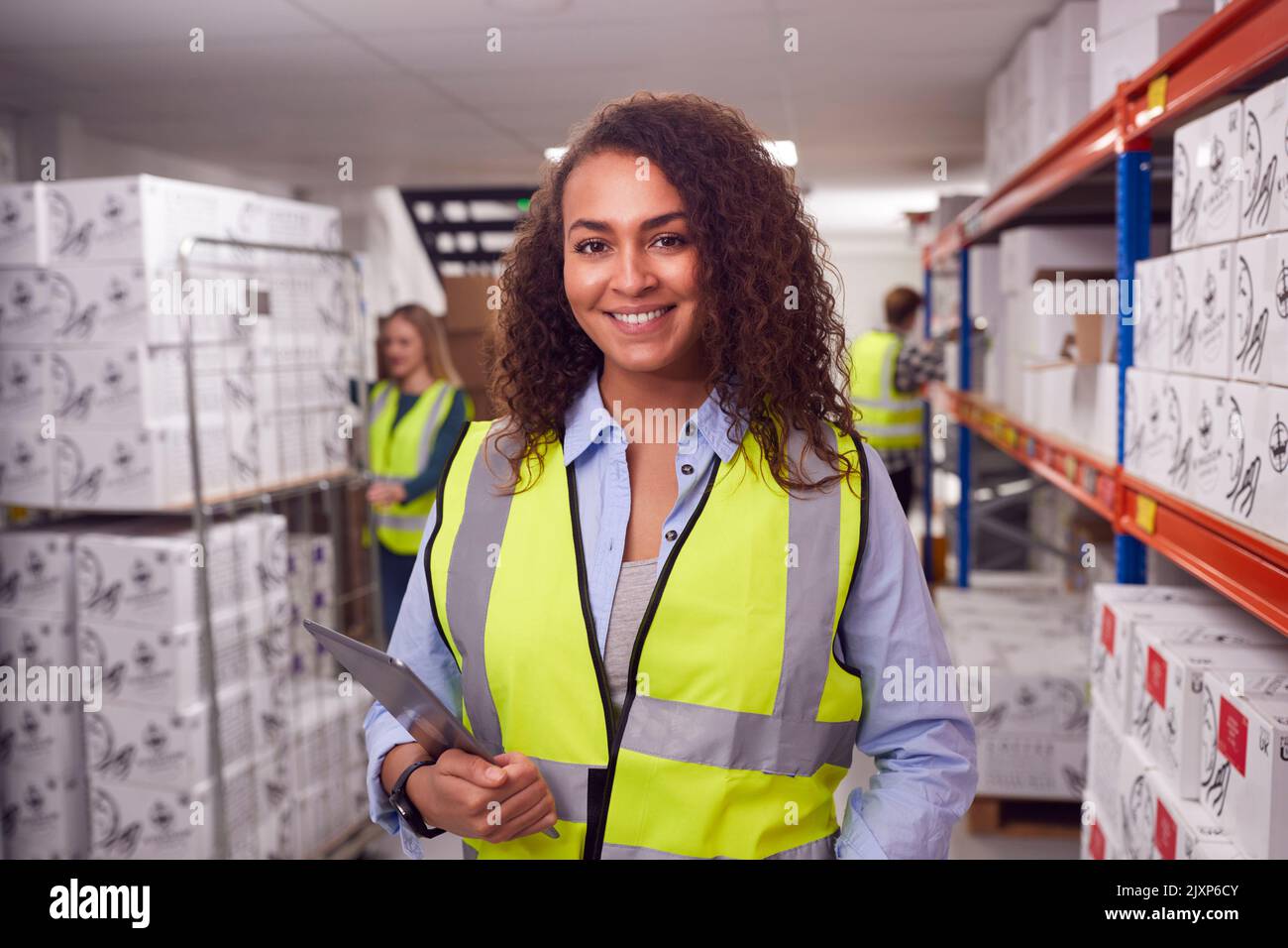 Portrait Of Female Worker Inside Busy Warehouse Checking Stock On ...