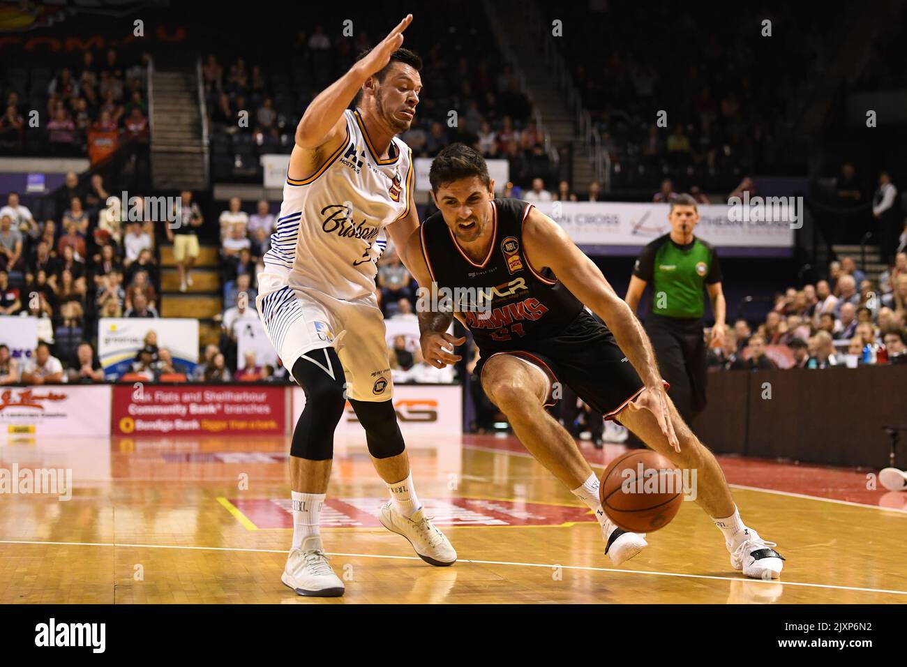 Todd Blanchfield of the Hawks comes under pressure from Jason Cade of ...