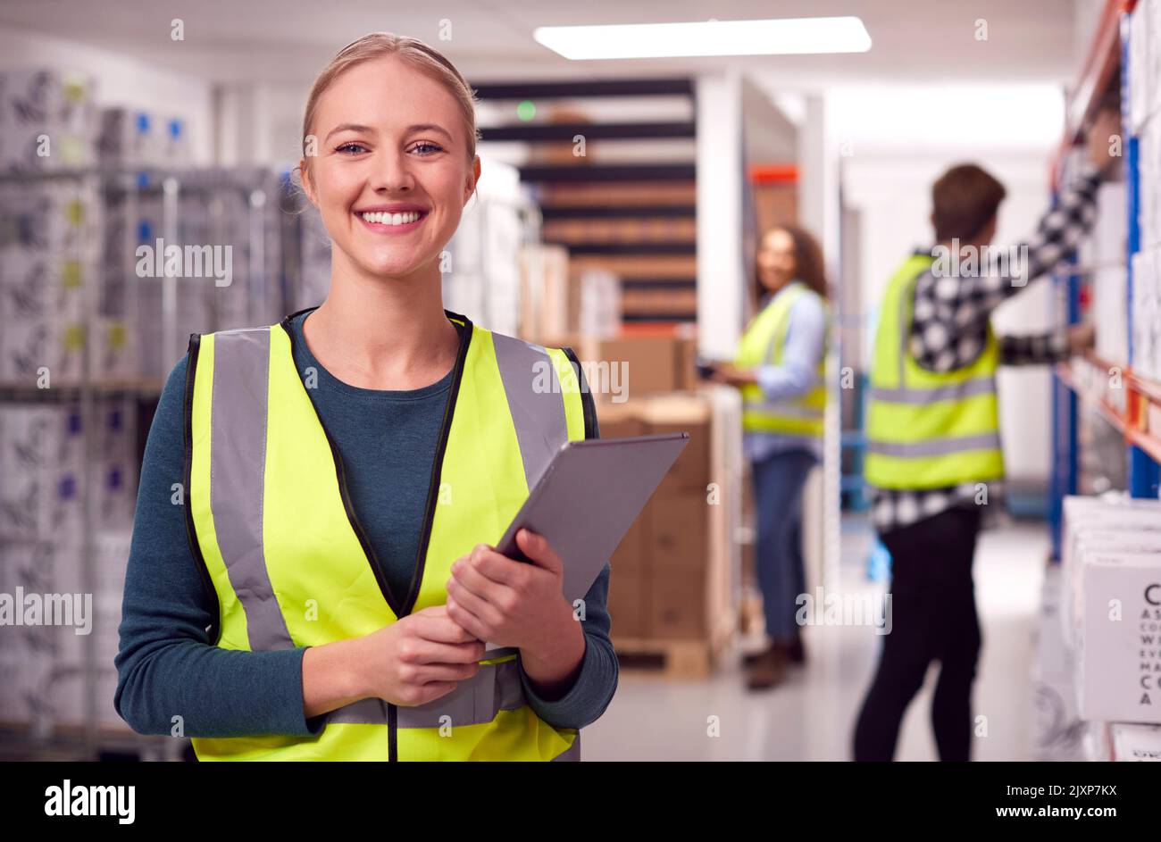 Portrait Of Female Worker Inside Busy Warehouse Checking Stock On ...