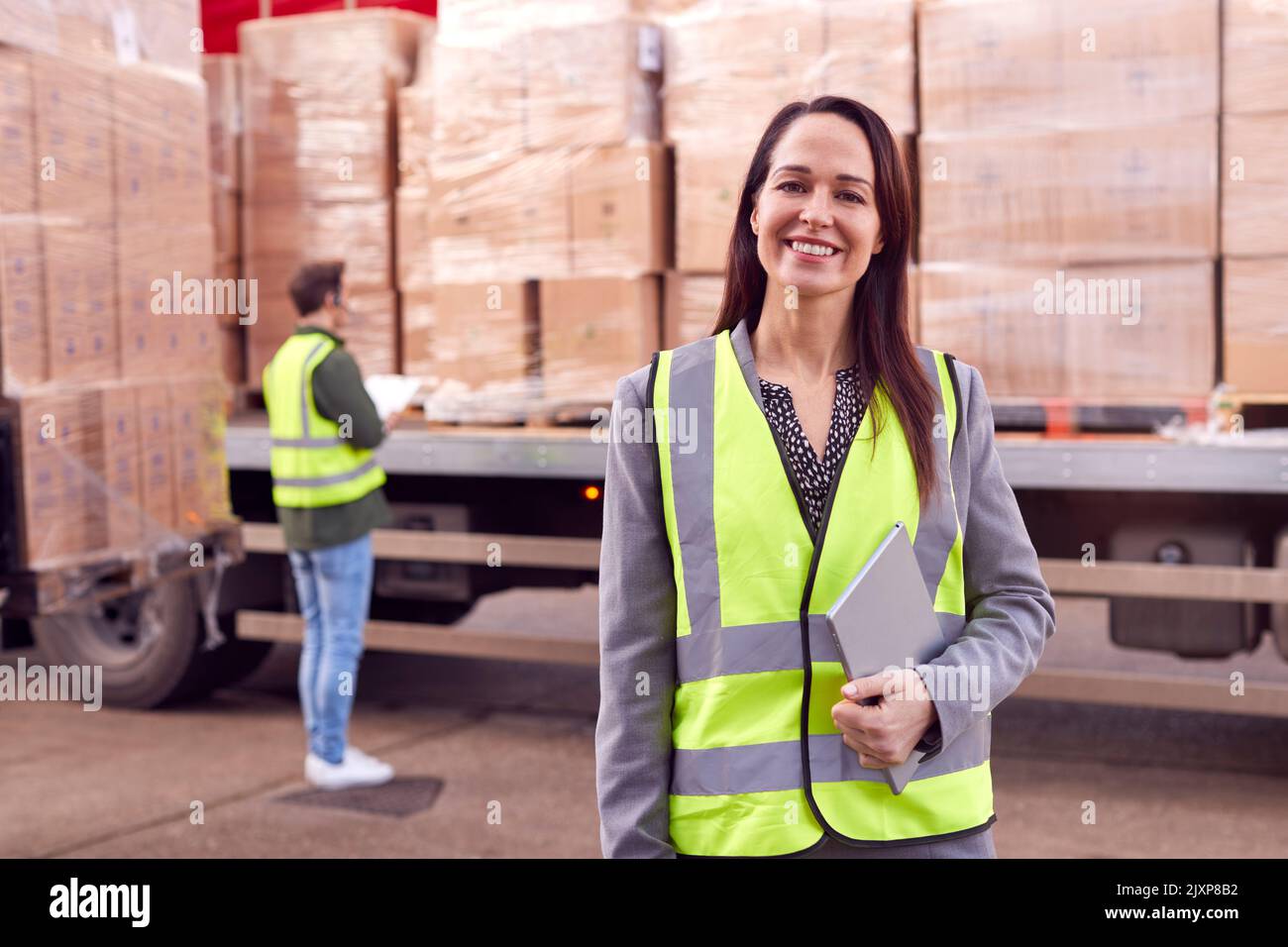 Portrait Of Female Freight Haulage Manager Standing By Truck Being ...