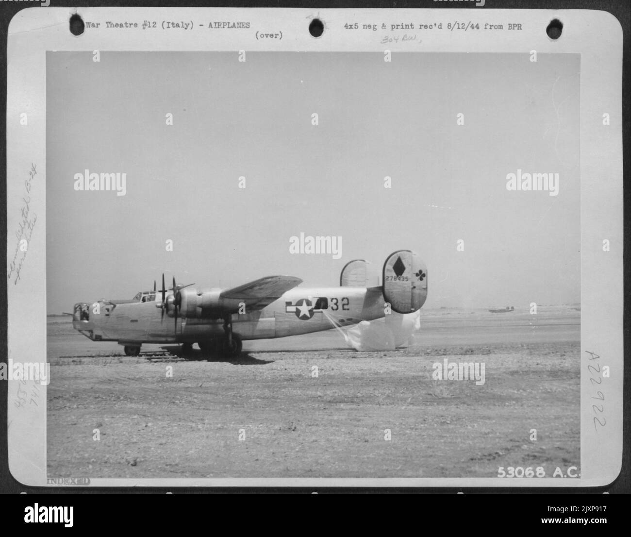 With parachutes billowing behind it, a Consolidated B-24 Liberator ...