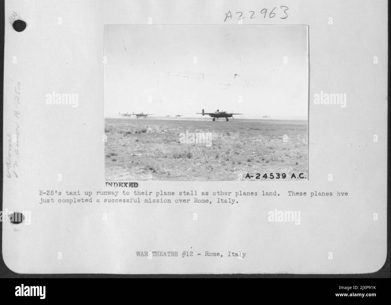 B'25's taxi up runway to their plane stall as other planes land. These ...