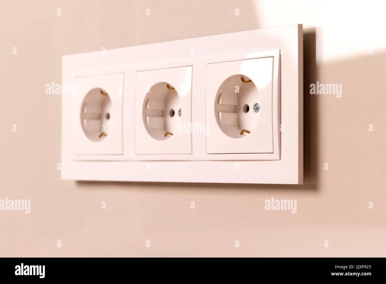 Group of white european electrical outlets on modern beige wall ...