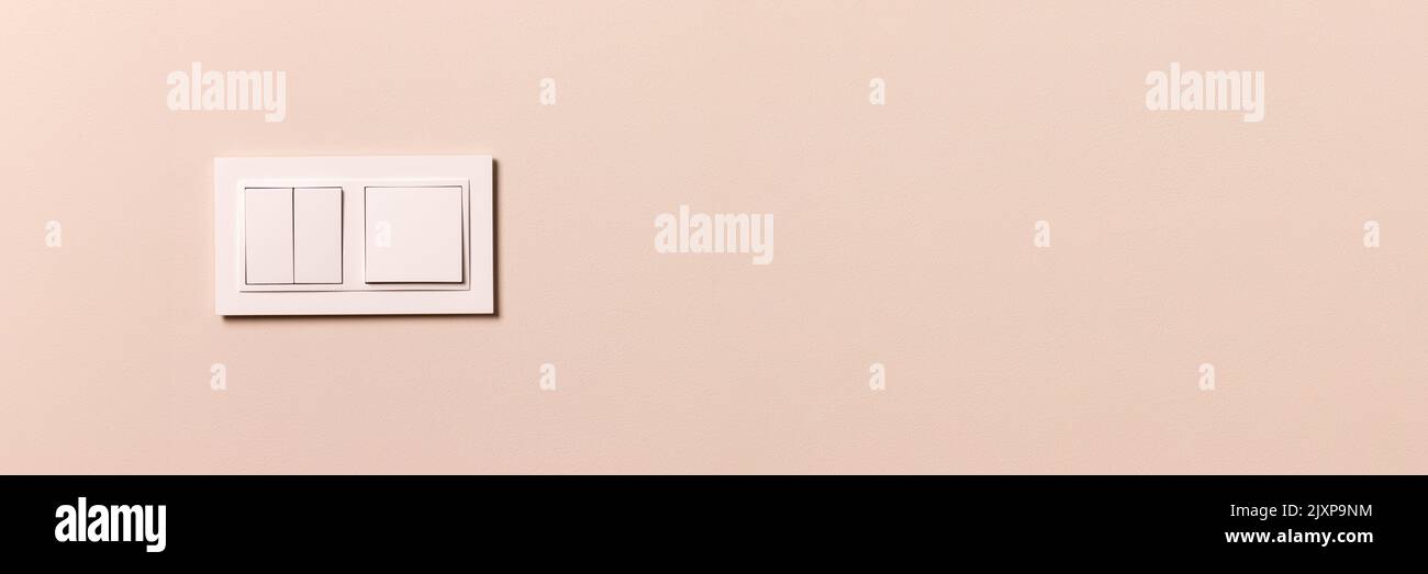Group of white electrical switches on modern beige wall with copy space ...