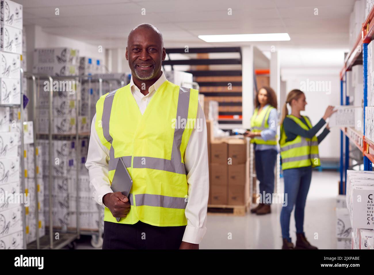 Portrait Of Team Leader With Digital Tablet In Warehouse With Staff ...