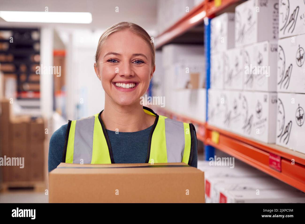 Portrait Of Female Worker Holding Box Inside Warehouse Stock Photo - Alamy