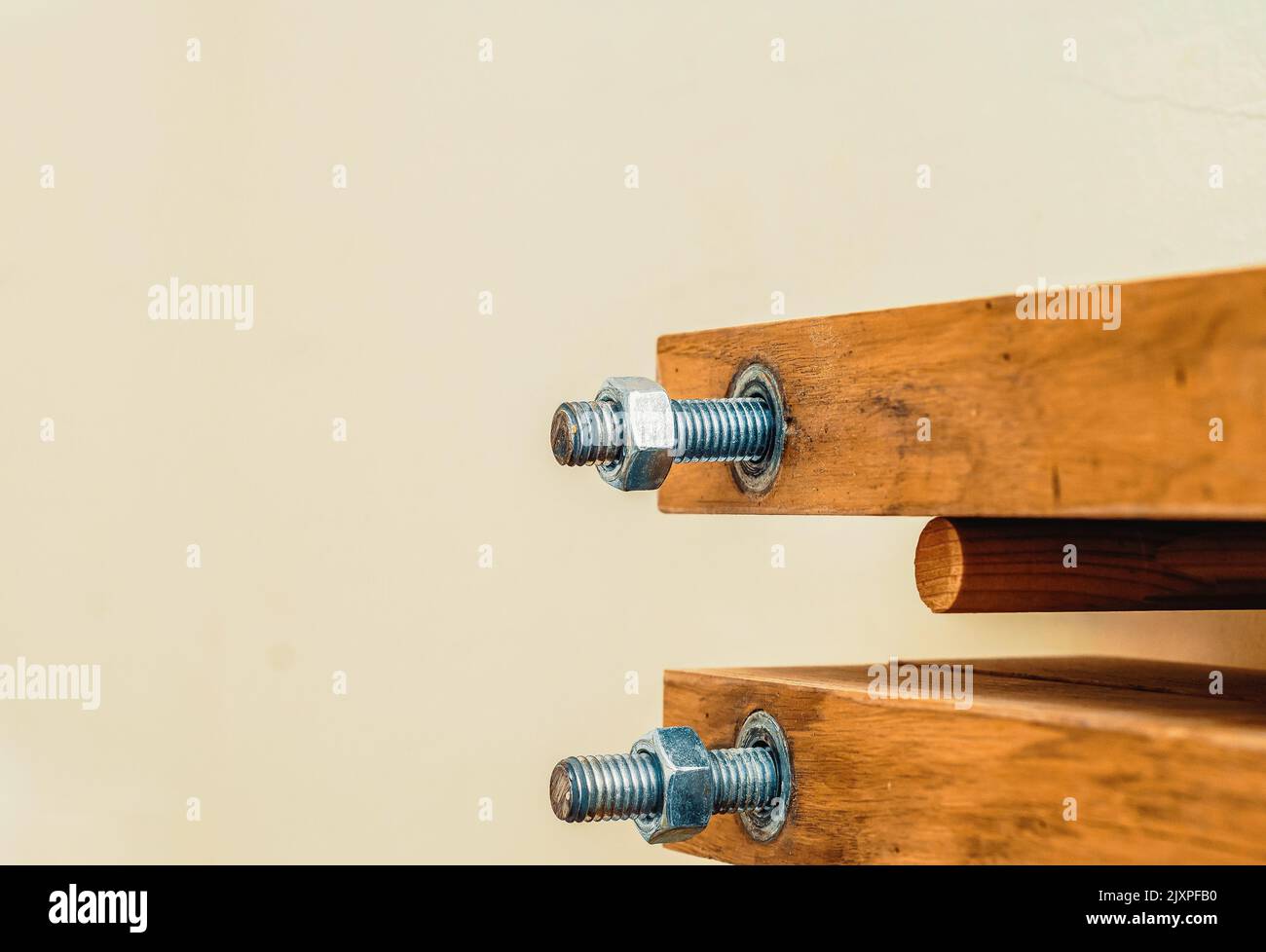 Fastening a bolt nut on wooden bar Stock Photo - Alamy
