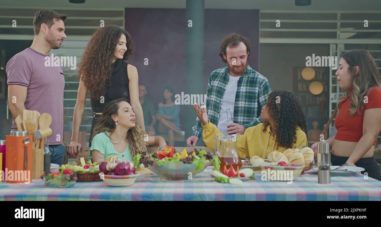 Family meeting at backyard barbecue party. BBQ table. Diverse friends ...