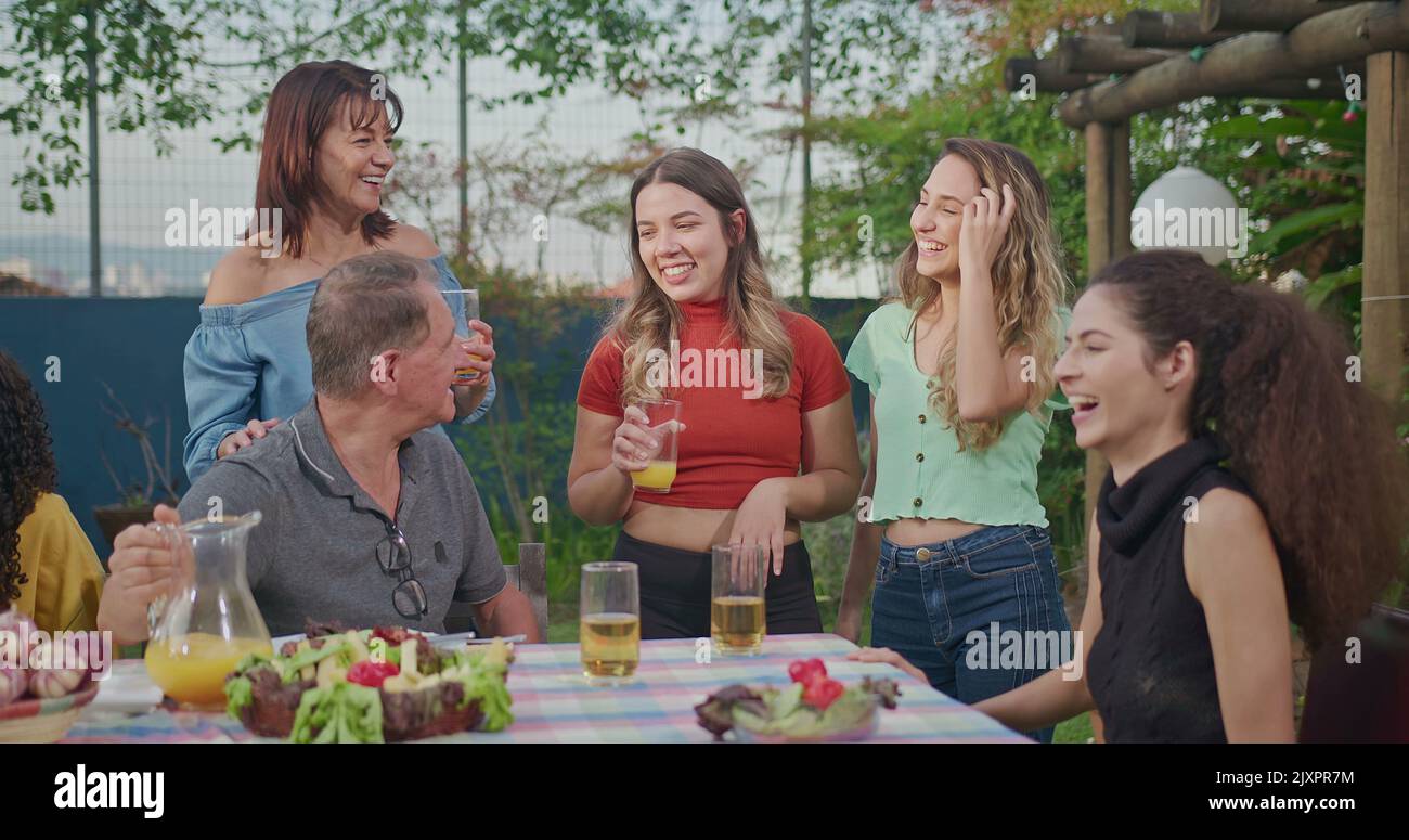 Joyful smiling people celebrating holidays in home garden party. Group ...