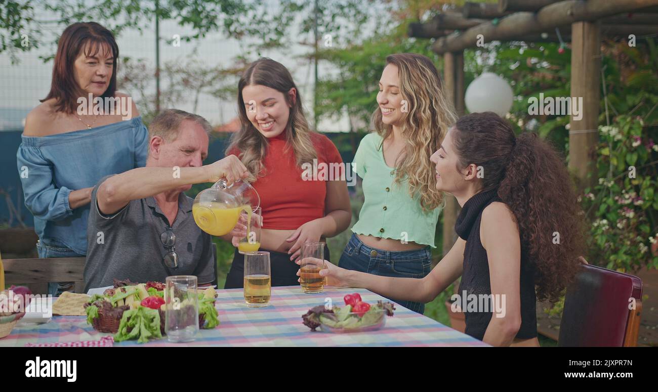 Joyful smiling people celebrating holidays in home garden party. Group ...