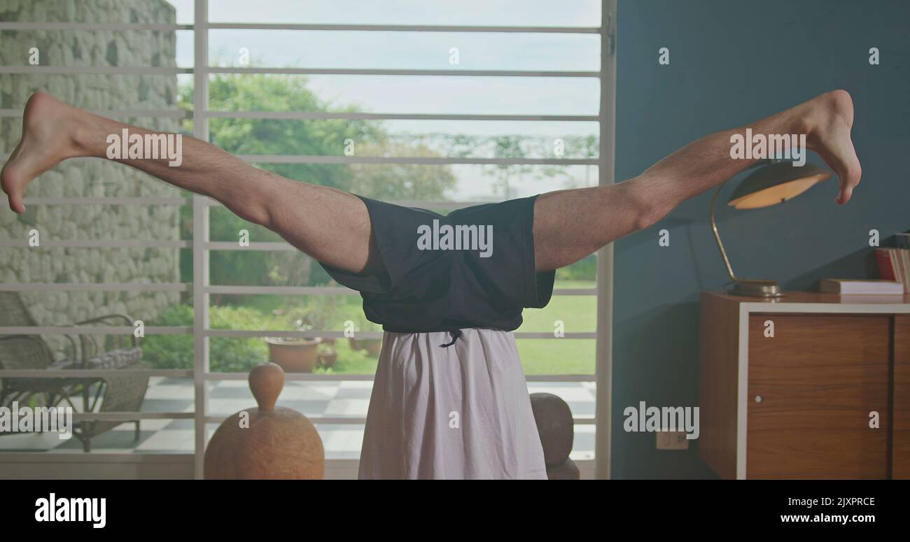 Athlete man balances upside down in yoga practice. Person practicing ...